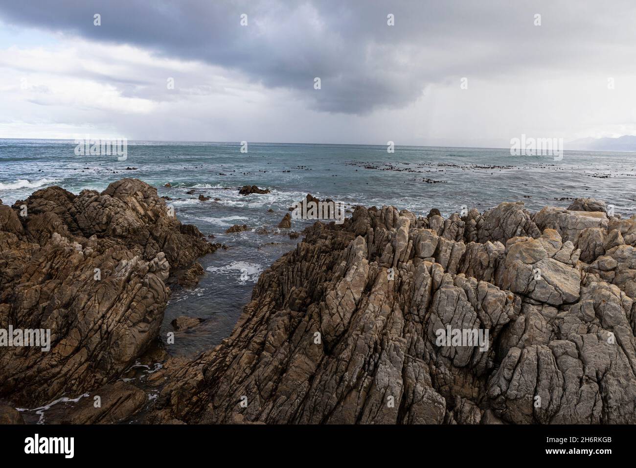 Rocky jagged coastline, eroded sandstone rock, view out to the ocean ...