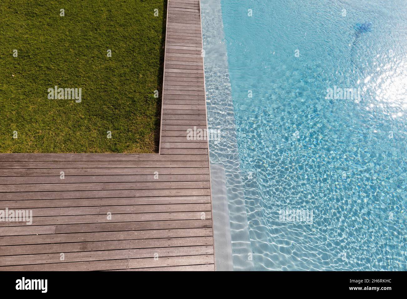 Aerial view of a swimming pool with a decking edge and plants in a ...