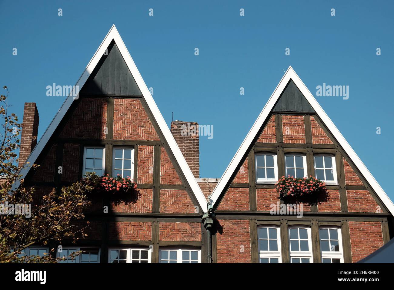 Gable buildings decorated with flowers under the sunlight and a blue ...