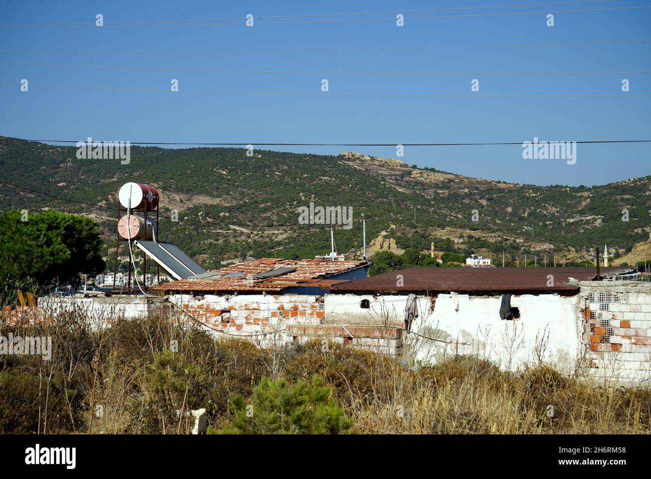 Old rusty building surrounded by hills covered in greenery under the ...