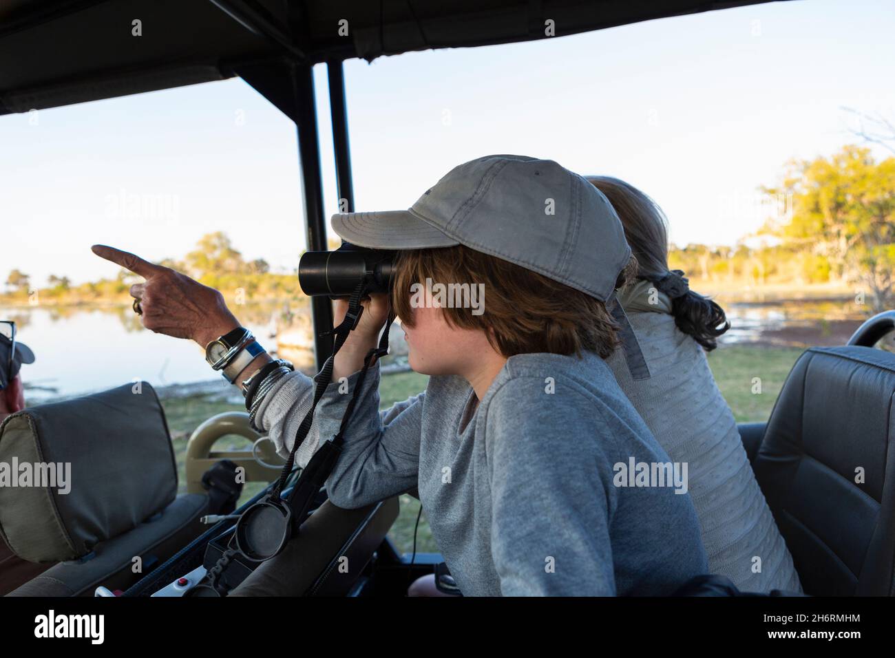 Boy in a safari jeep looking through binoculars Stock Photo - Alamy