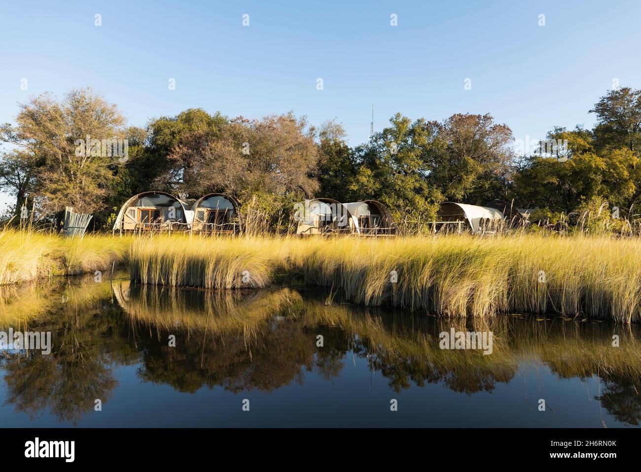 Small group of permanent safari camp tents by a waterway Stock Photo ...