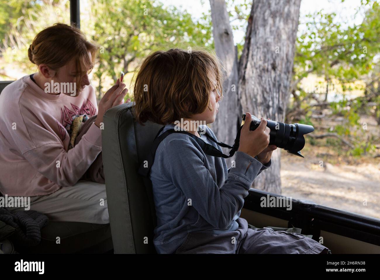 Young boy using a camera sitting in a jeep Stock Photo - Alamy