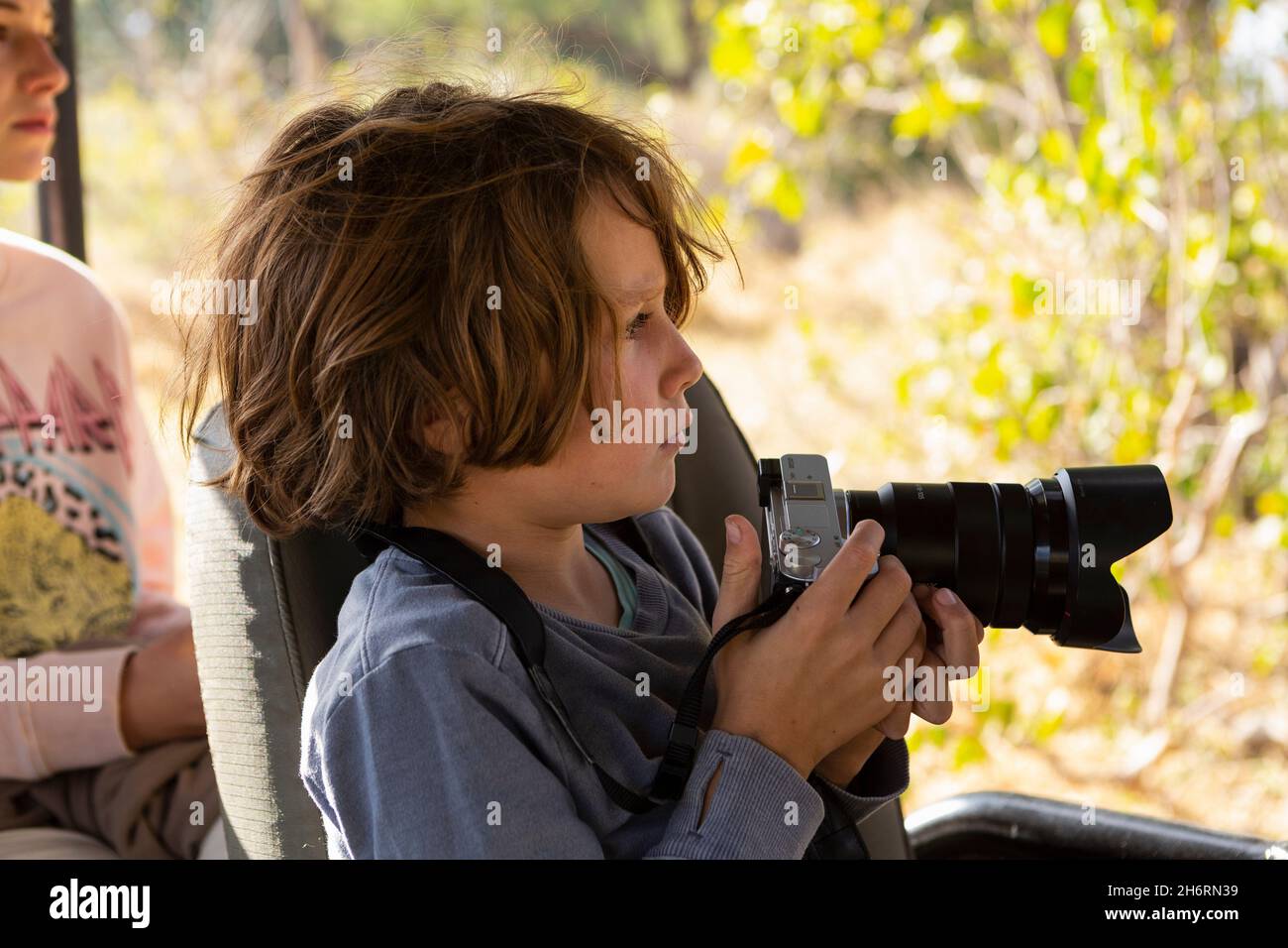 Young boy using a camera sitting in a jeep Stock Photo - Alamy