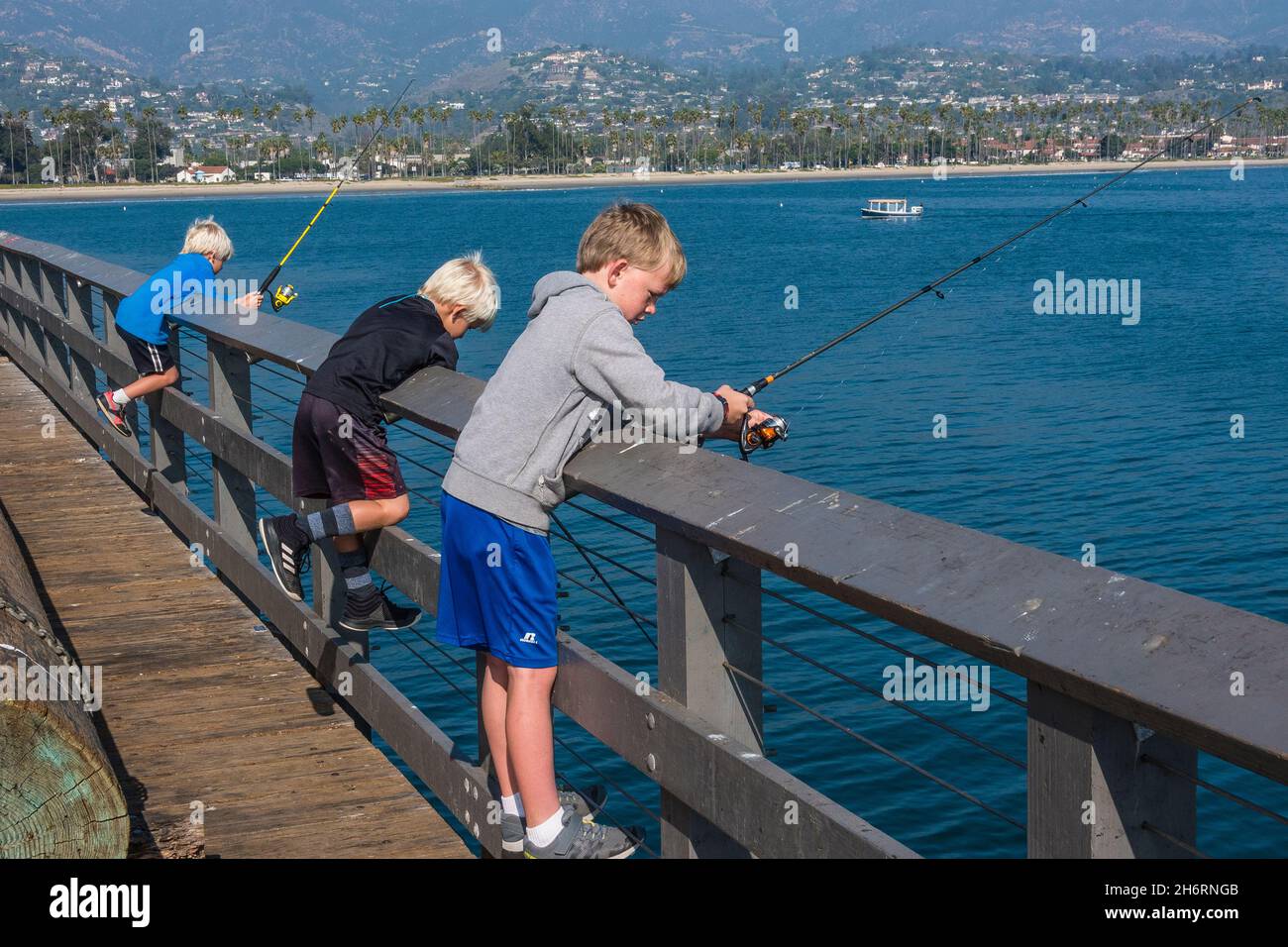 Three young brothers fishing off of a wharf Stock Photo - Alamy