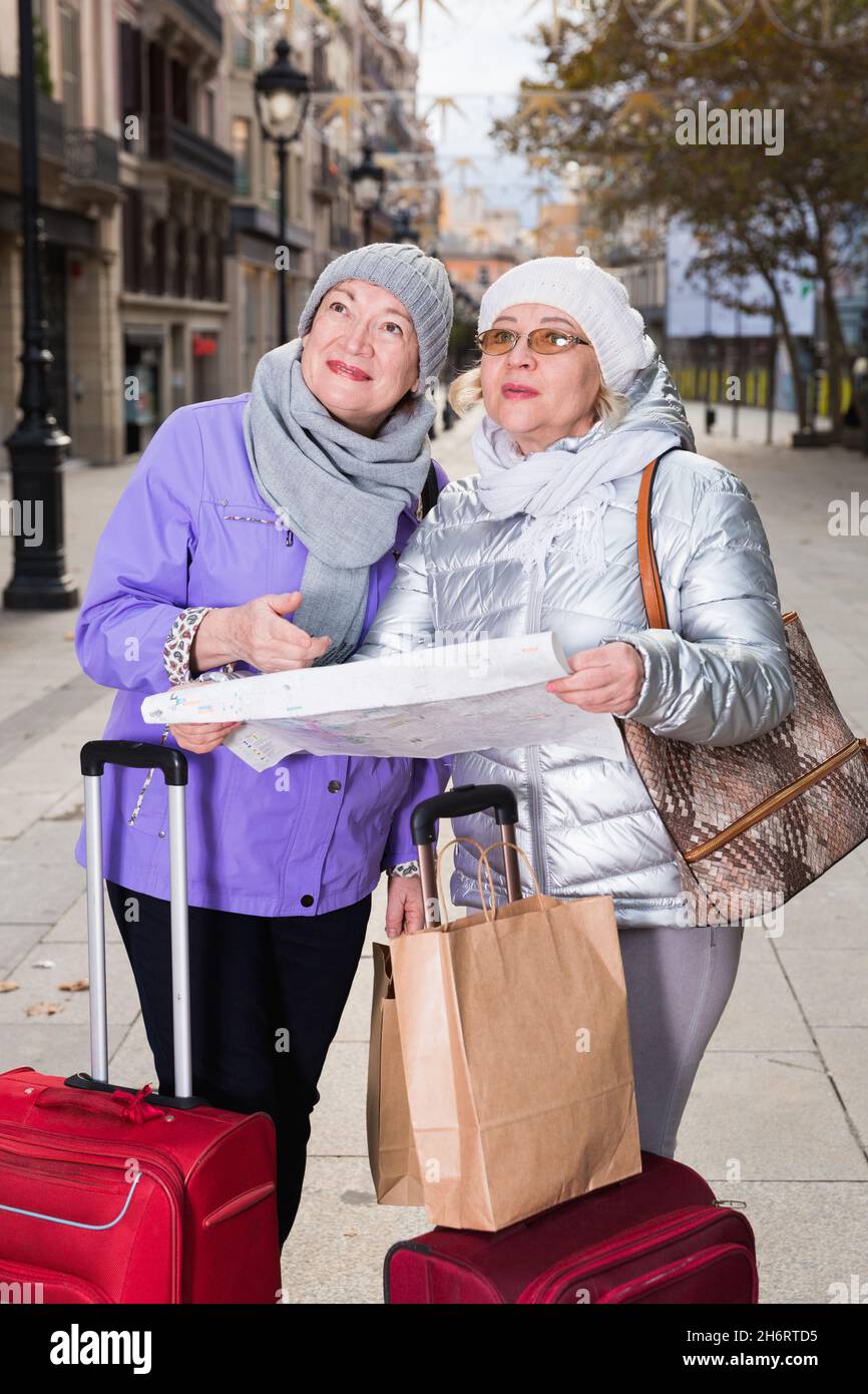 Elderly women tourists with city guide Stock Photo - Alamy