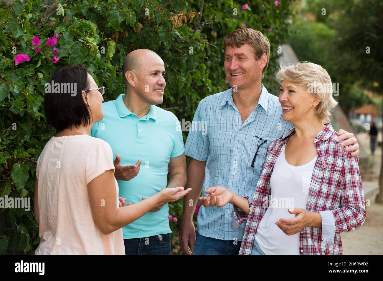 Smiling couples walking and talking Stock Photo - Alamy