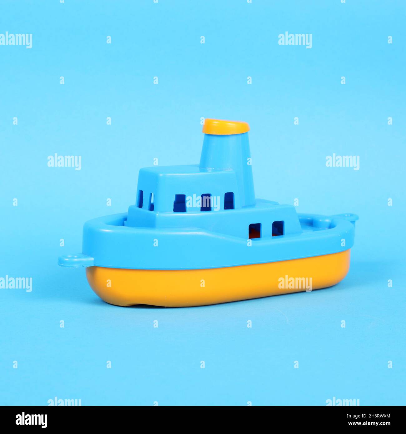 little plastic toy ship on the blue background Stock Photo - Alamy
