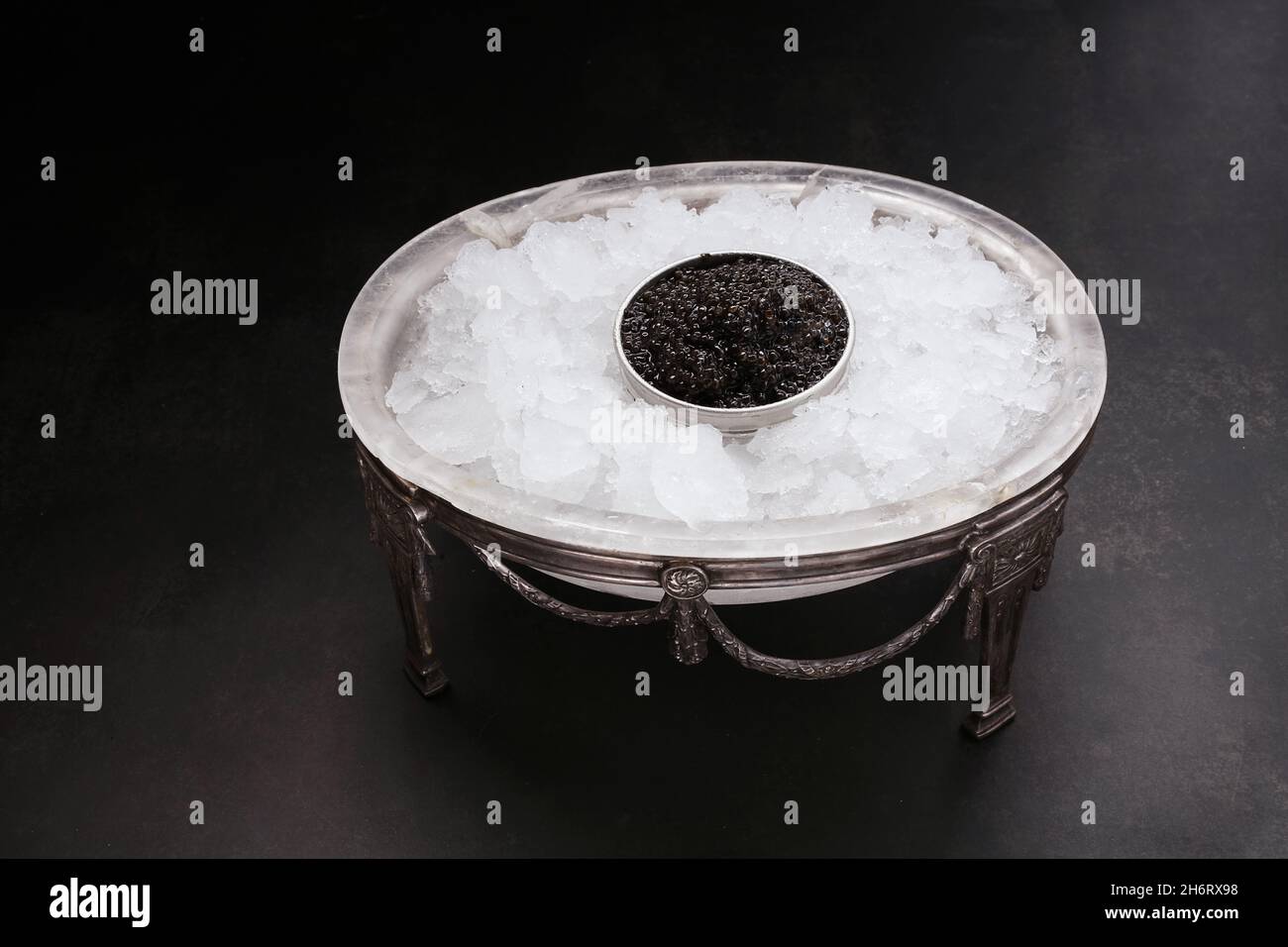 caviar in a metal box served in an antique caviar set with crushed ice ...