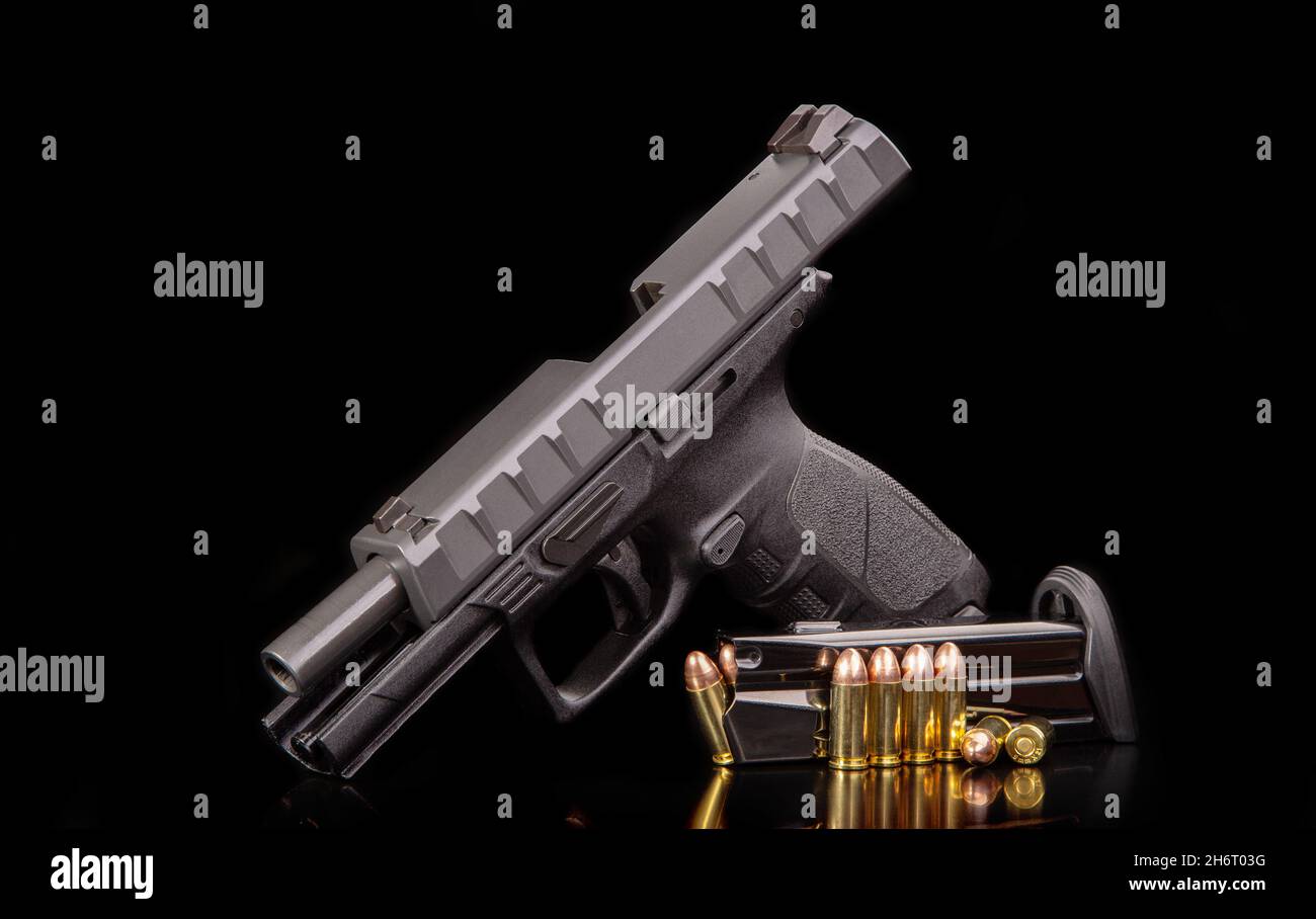Discharged weapon. Black modern gun and ammunition for it on a dark ...