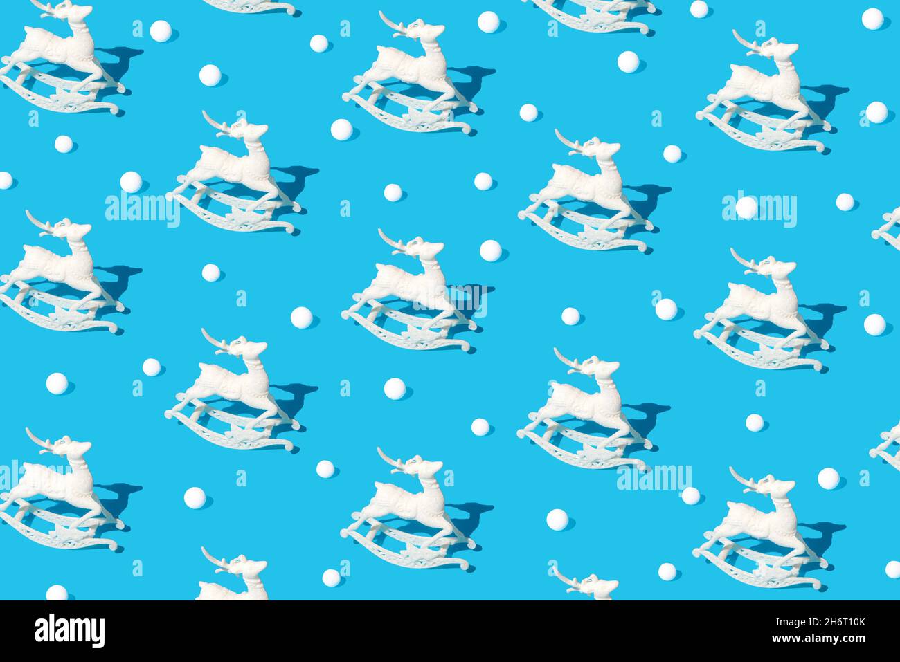 Reindeer on sledge with snowballs pattern, on pastel blue background ...