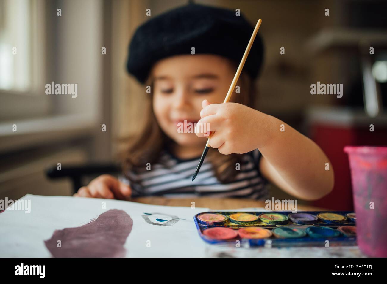 Young girl painting with a brush and watercolors Stock Photo - Alamy