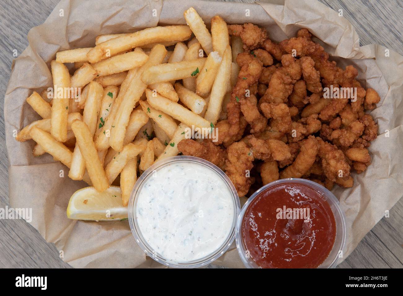 Overhead view of combination basket full of deep fried clams and a side ...