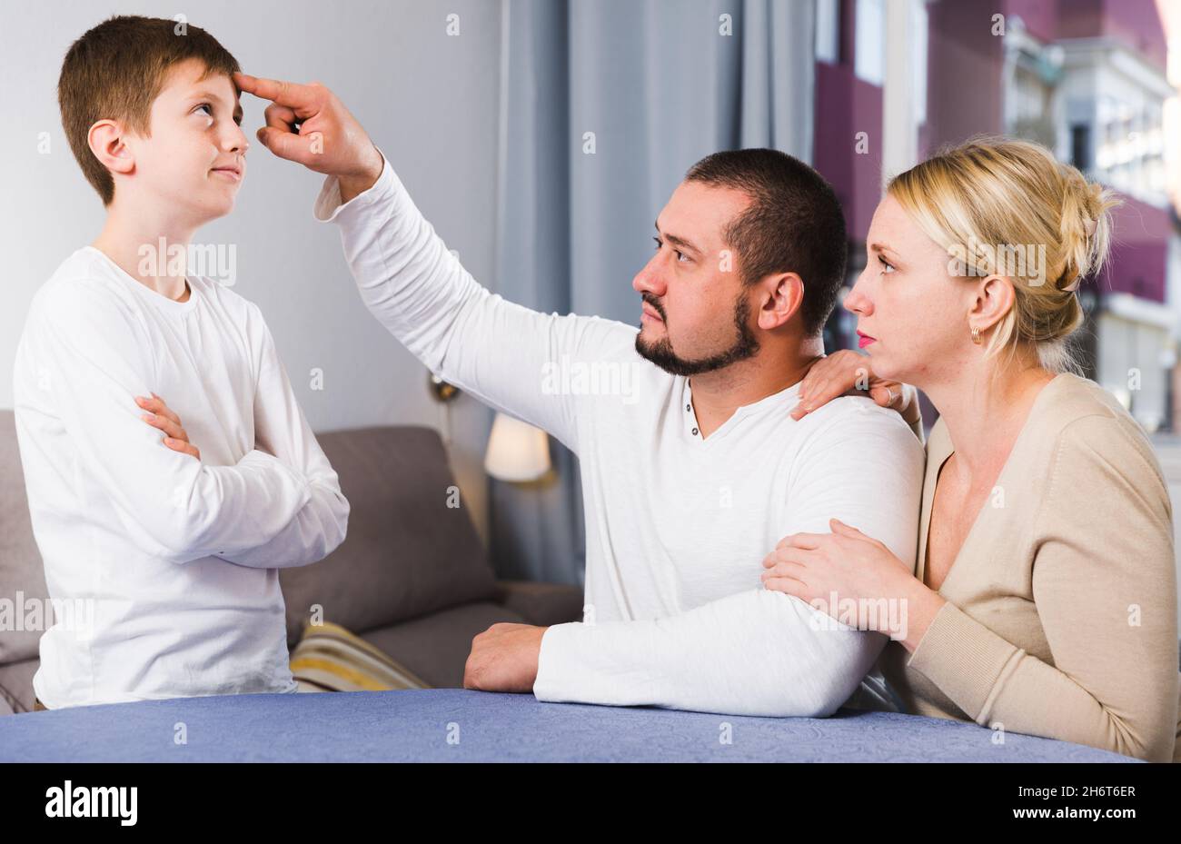 Serious parents scolding son Stock Photo - Alamy