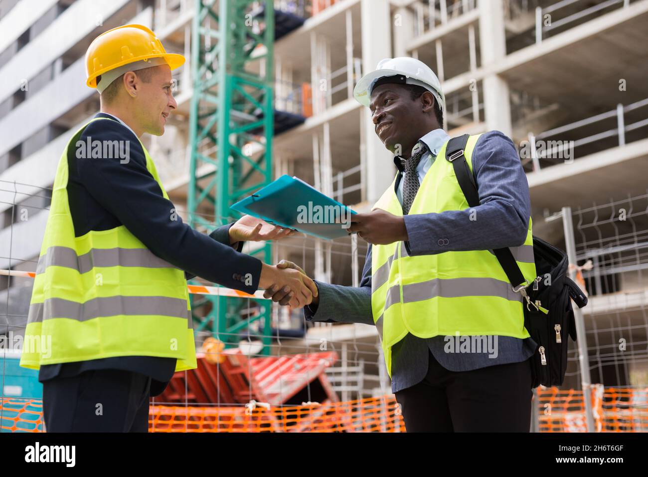 Engineers shaking hands on construction site Stock Photo - Alamy