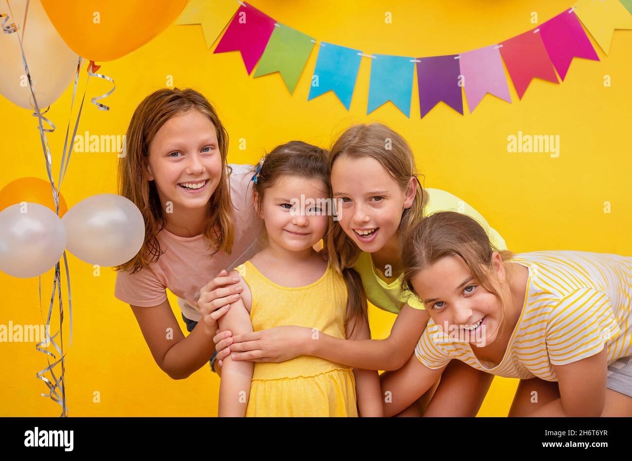 Children congratulate the birthday girl at a party on a yellow ...