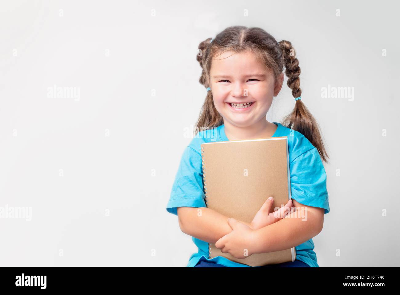 Portrait of the happy child with a book on the gray background Stock ...