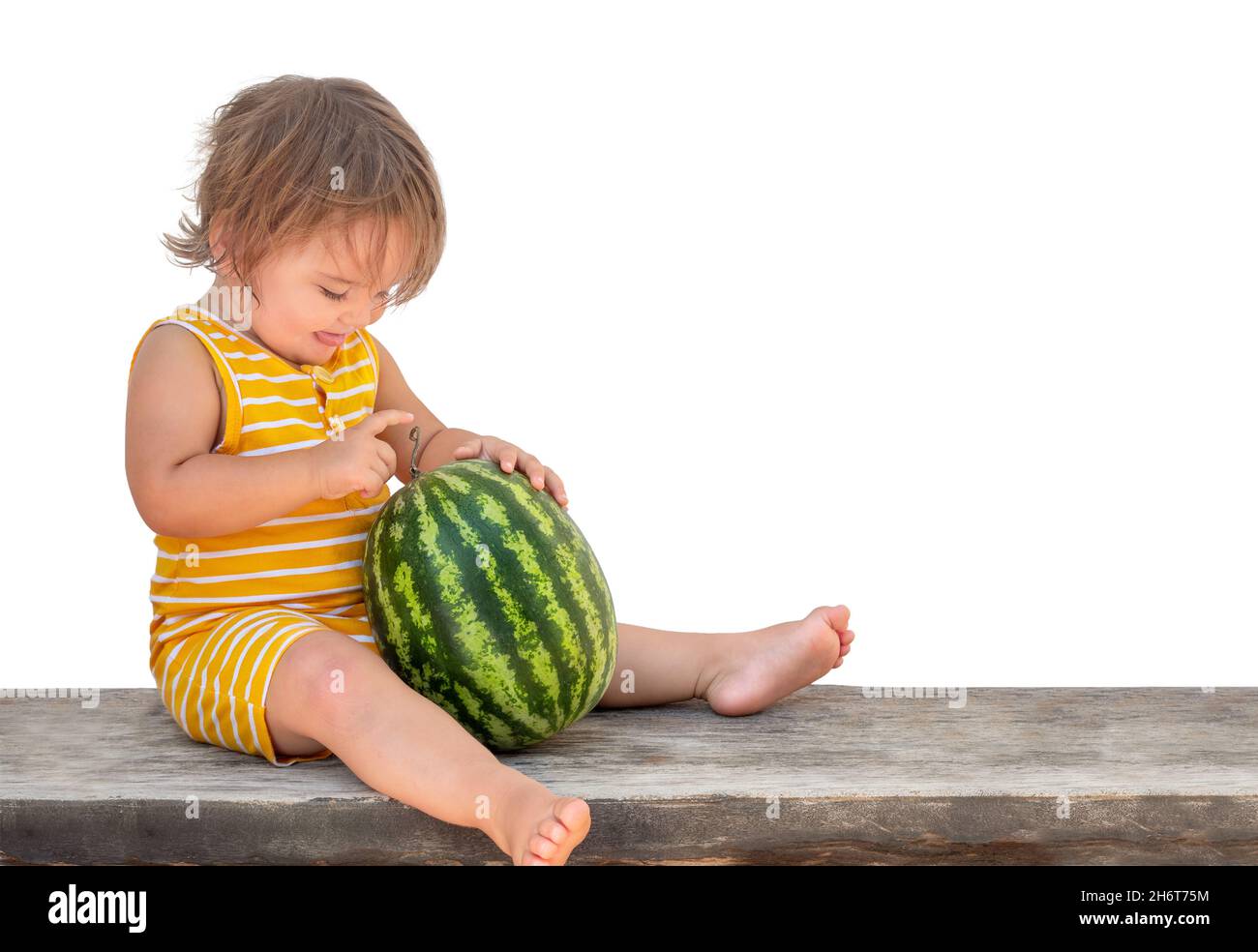Portrait of cute child playing with watermelon on wooden surface ...