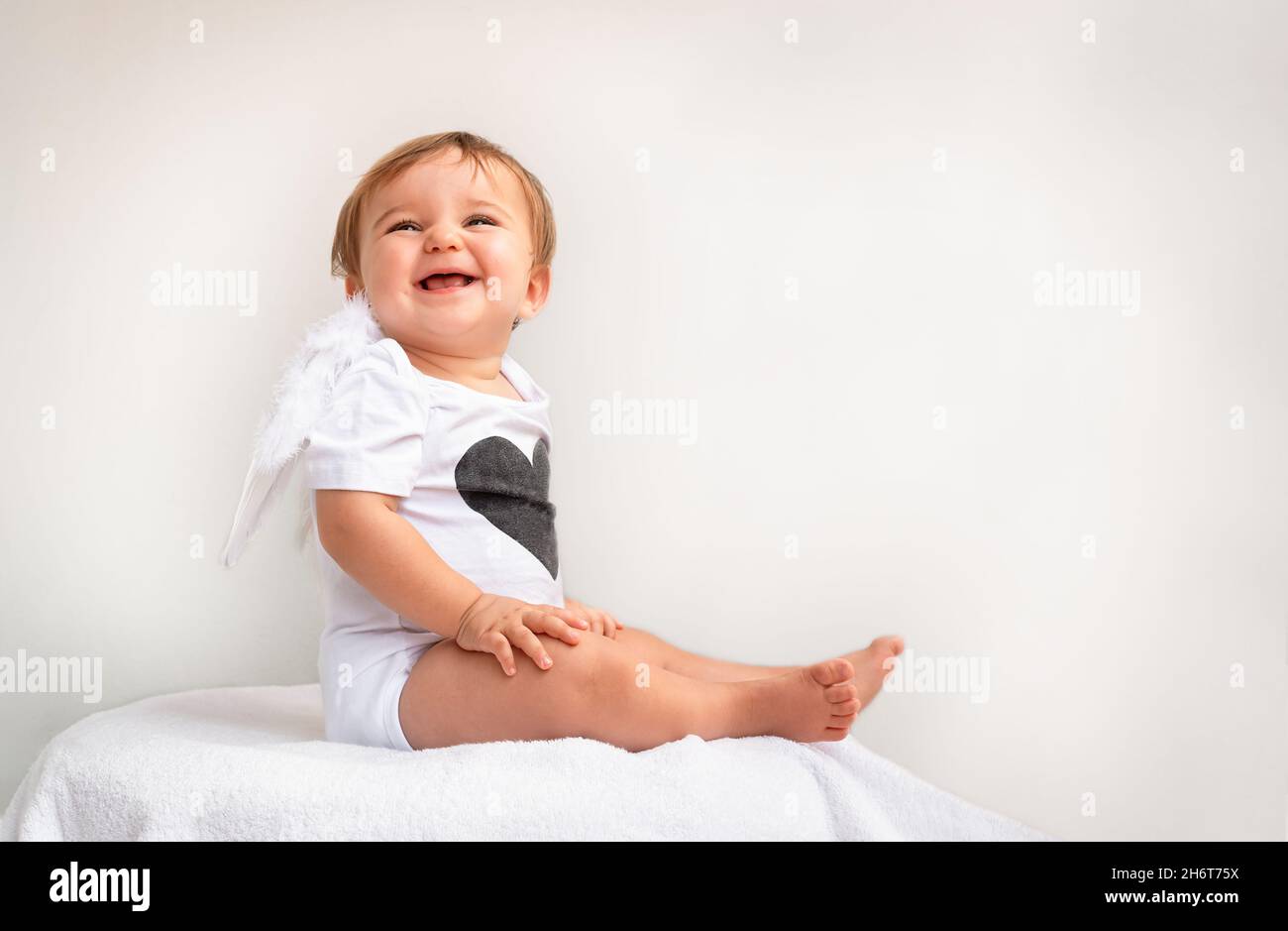 baby with angel wings and a heart on the body. cute baby on gray ...
