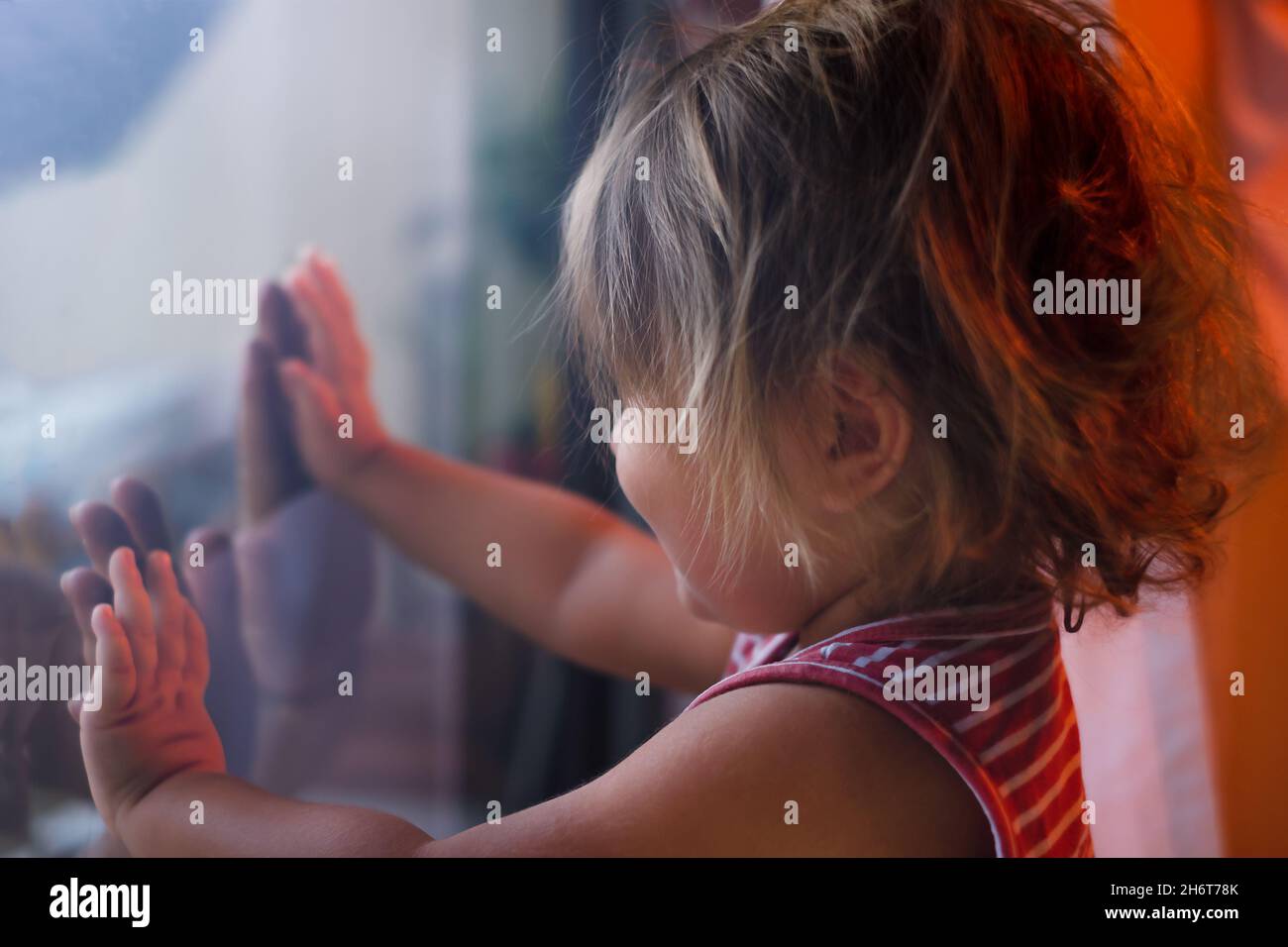A child and an adult touch their hands through the window Stock Photo ...