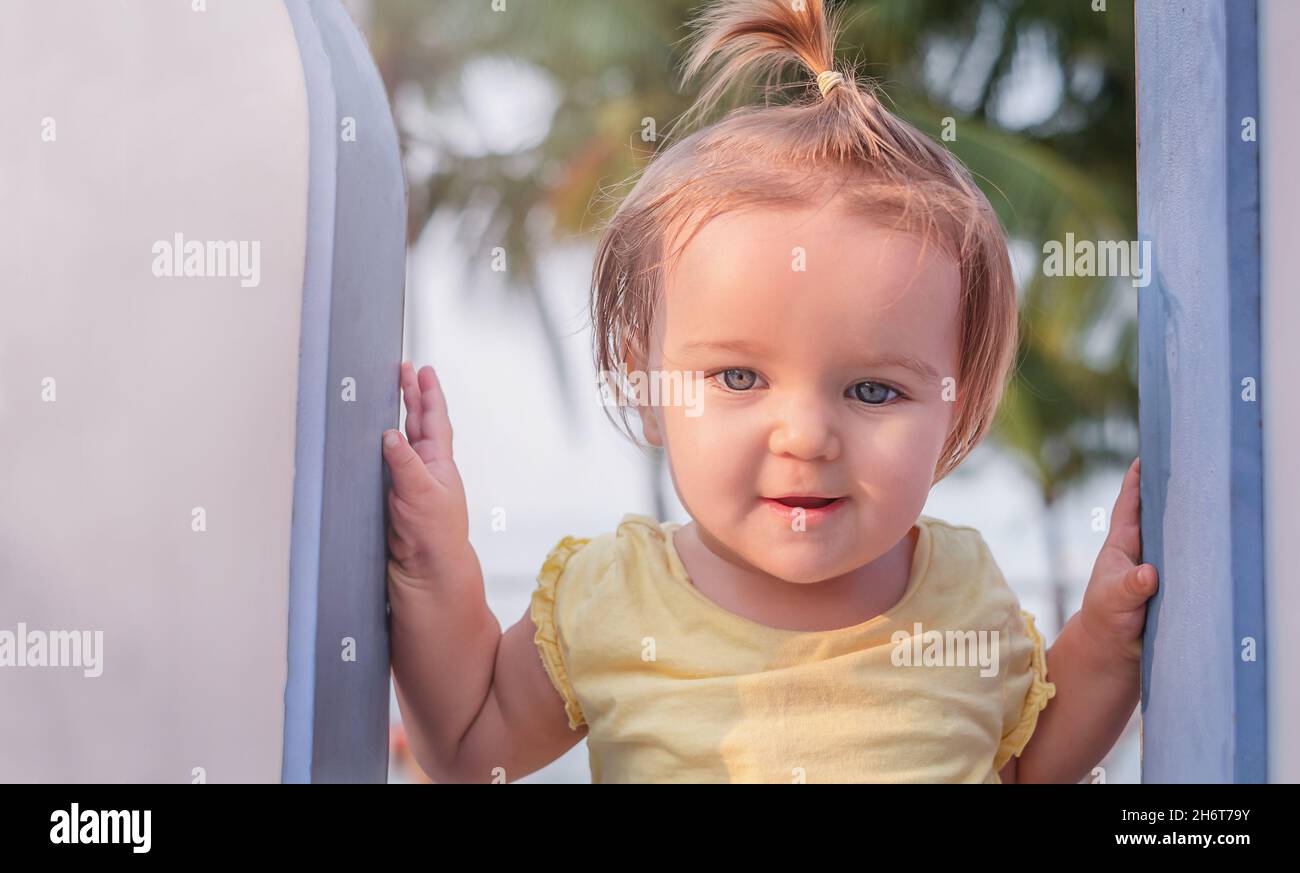 Cute baby peeking out from behind a billboard Stock Photo - Alamy