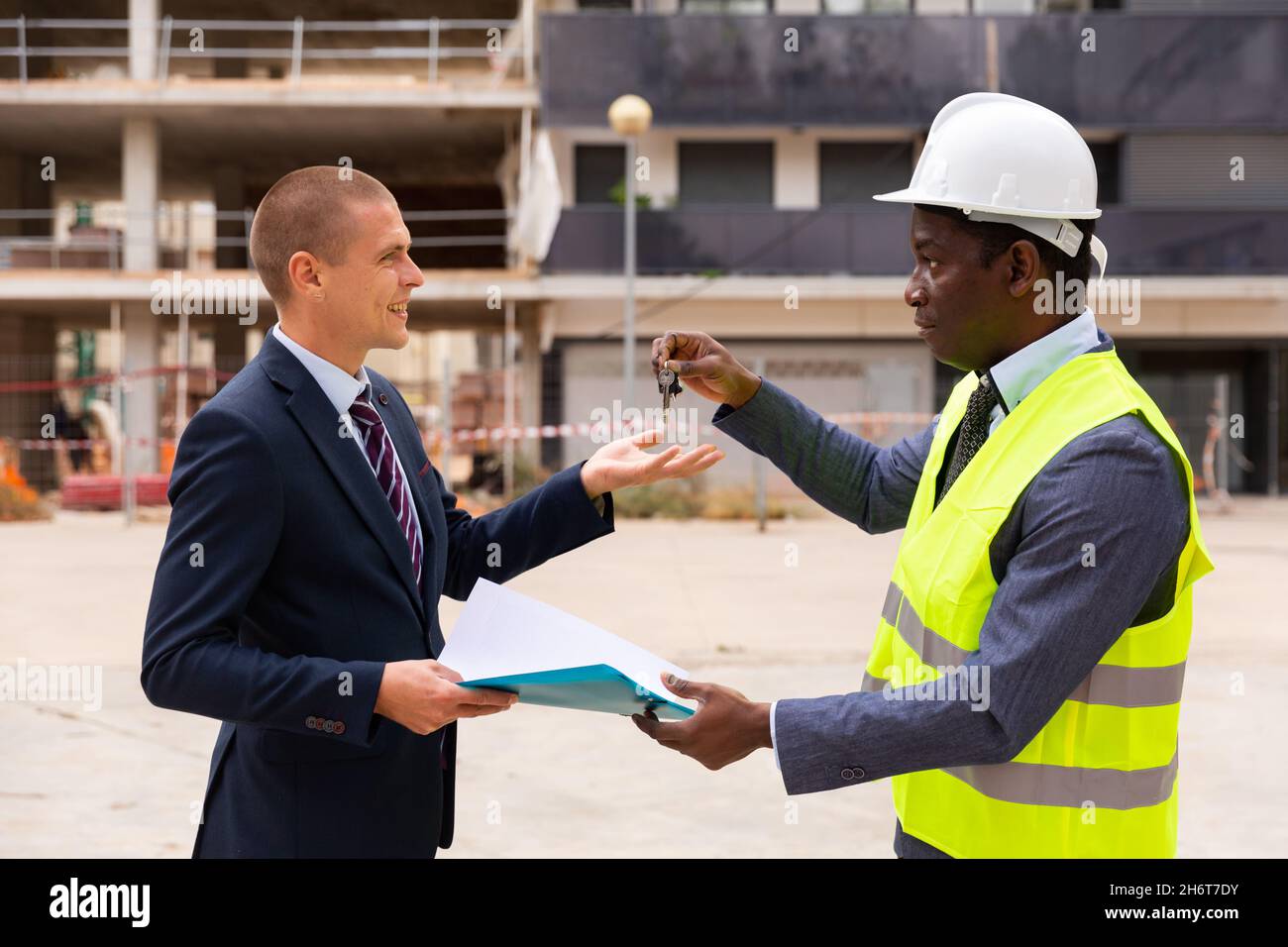African-american contractor hands the keys to a man customer Stock ...
