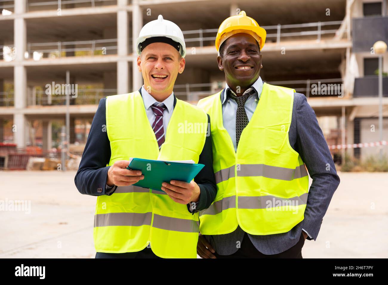 Positive builders standing on construction site Stock Photo - Alamy