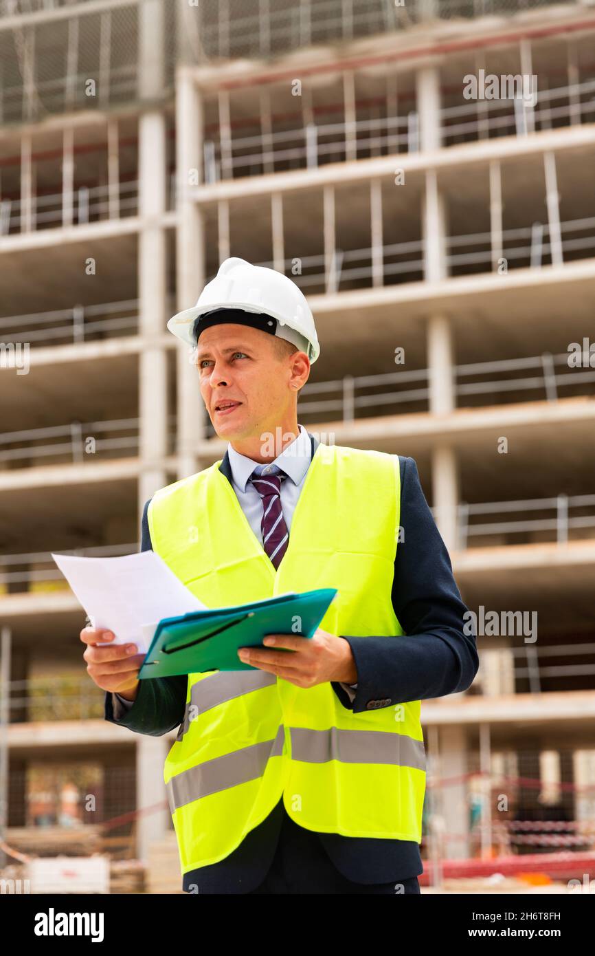 Engineer man analysing project documentation outdoors Stock Photo - Alamy