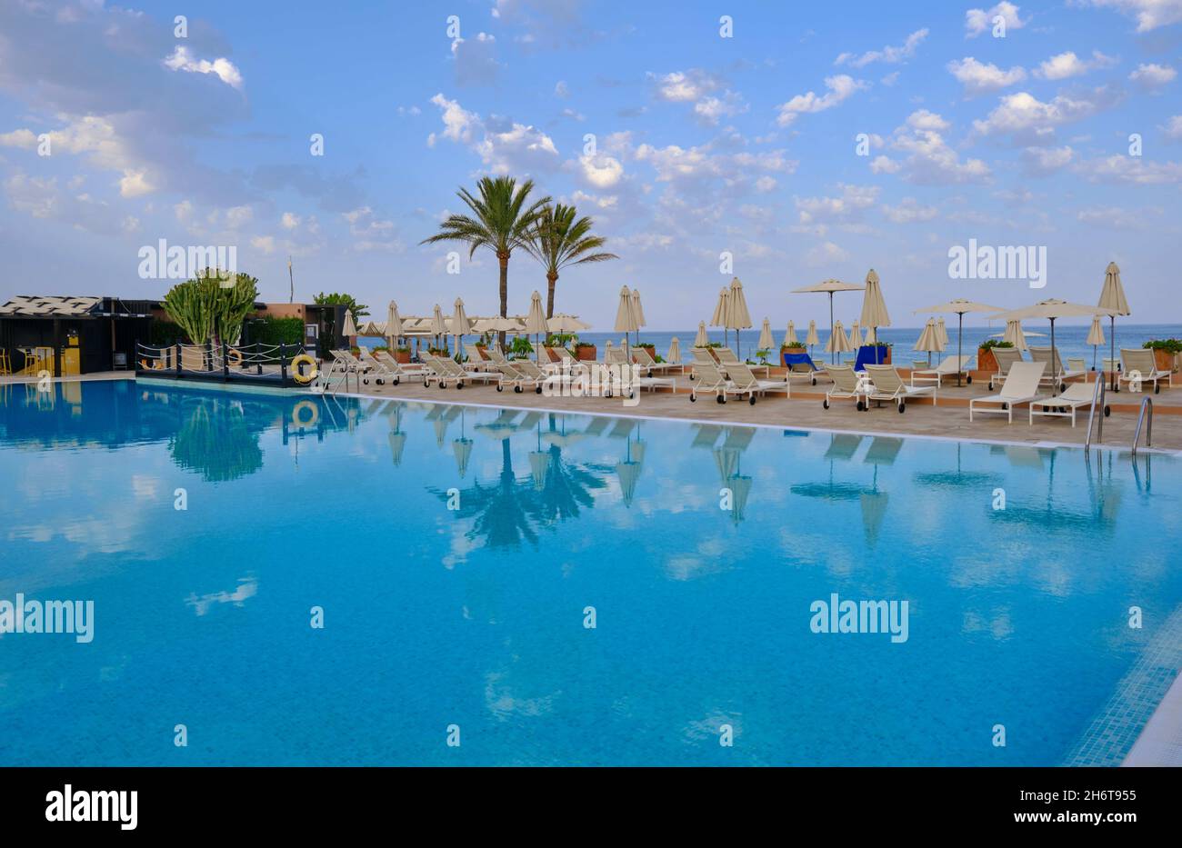Beautiful big swimming pool with sunbeds in a hotel on a sunny summer ...