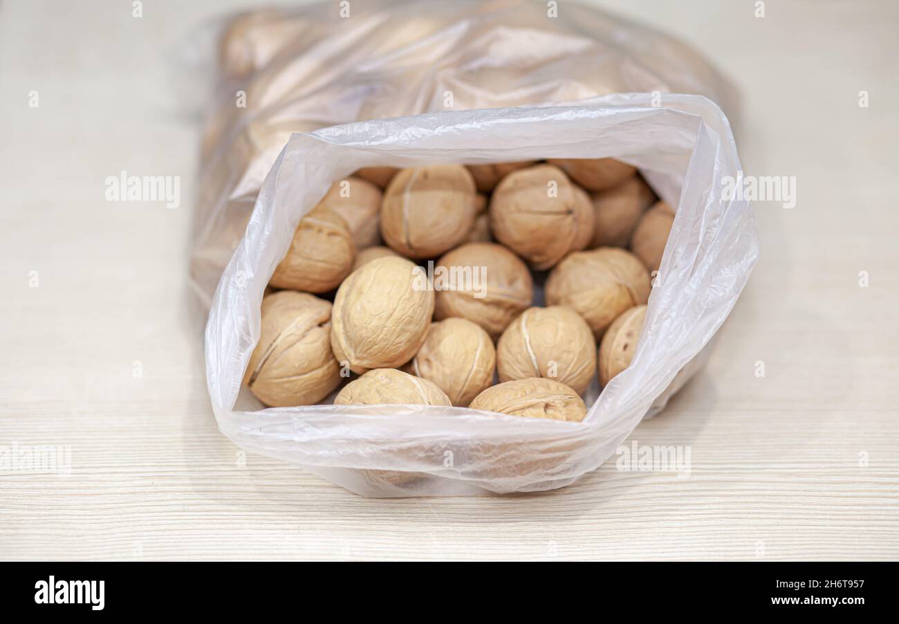 A lot of whole walnuts in a bag on a white background. Healthy, organic ...