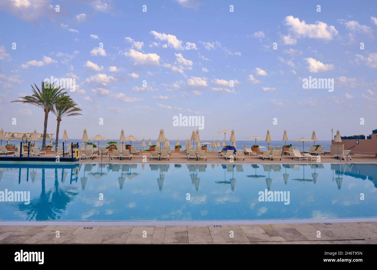 Beautiful big swimming pool with sunbeds in a hotel on a sunny summer ...