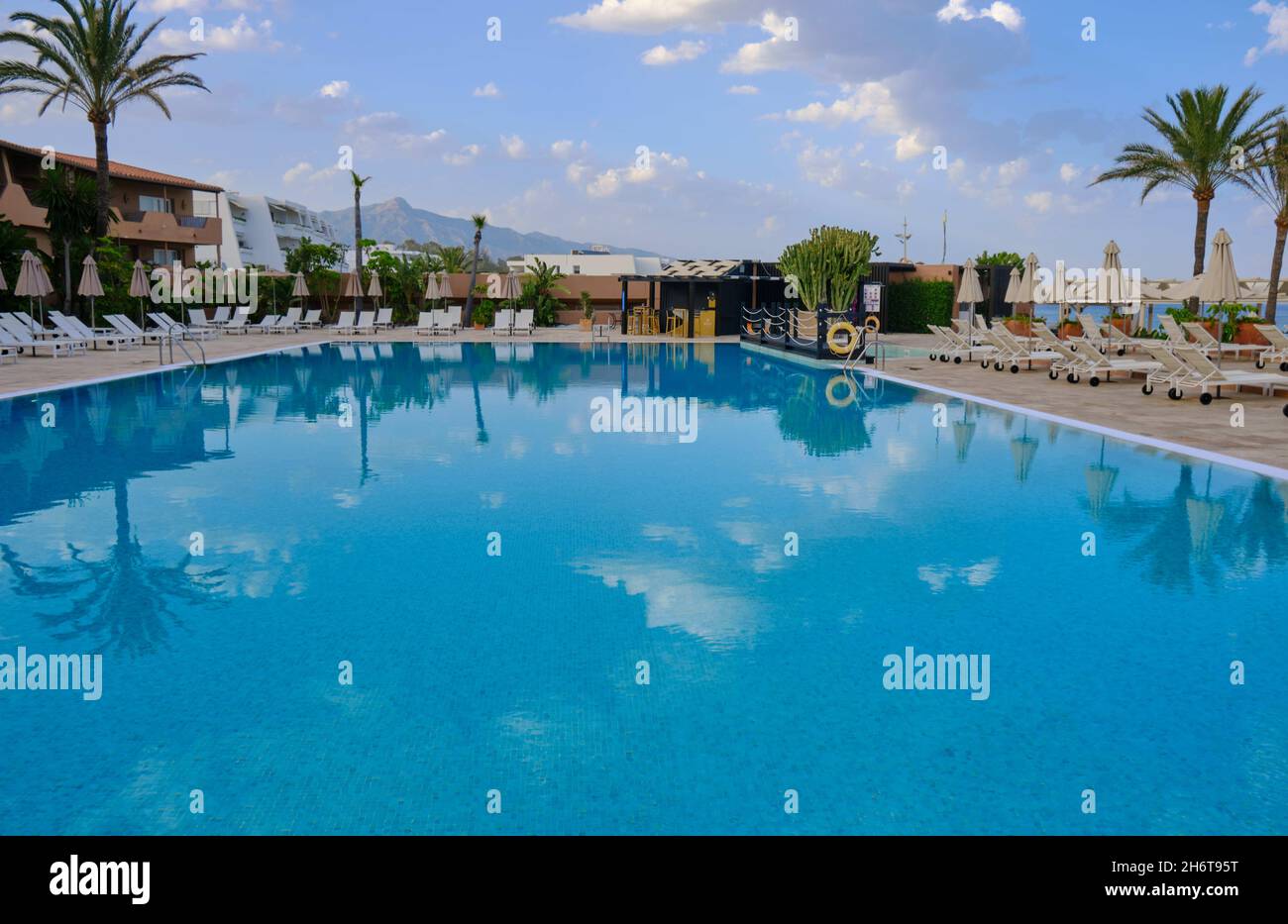 Beautiful big swimming pool with sunbeds in a hotel on a sunny summer ...