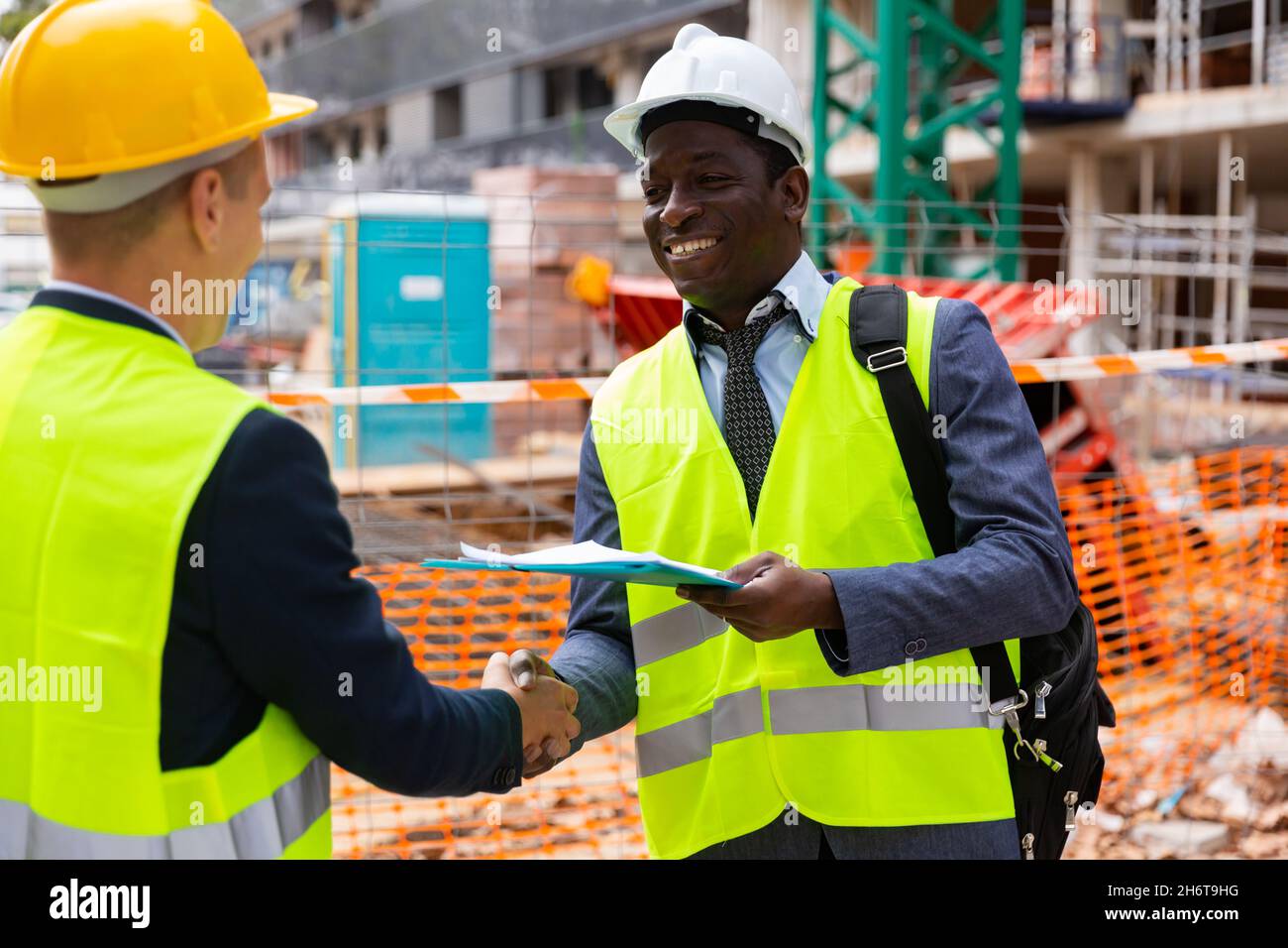 Two confident civil engineers exchange a friendly handshake Stock Photo ...