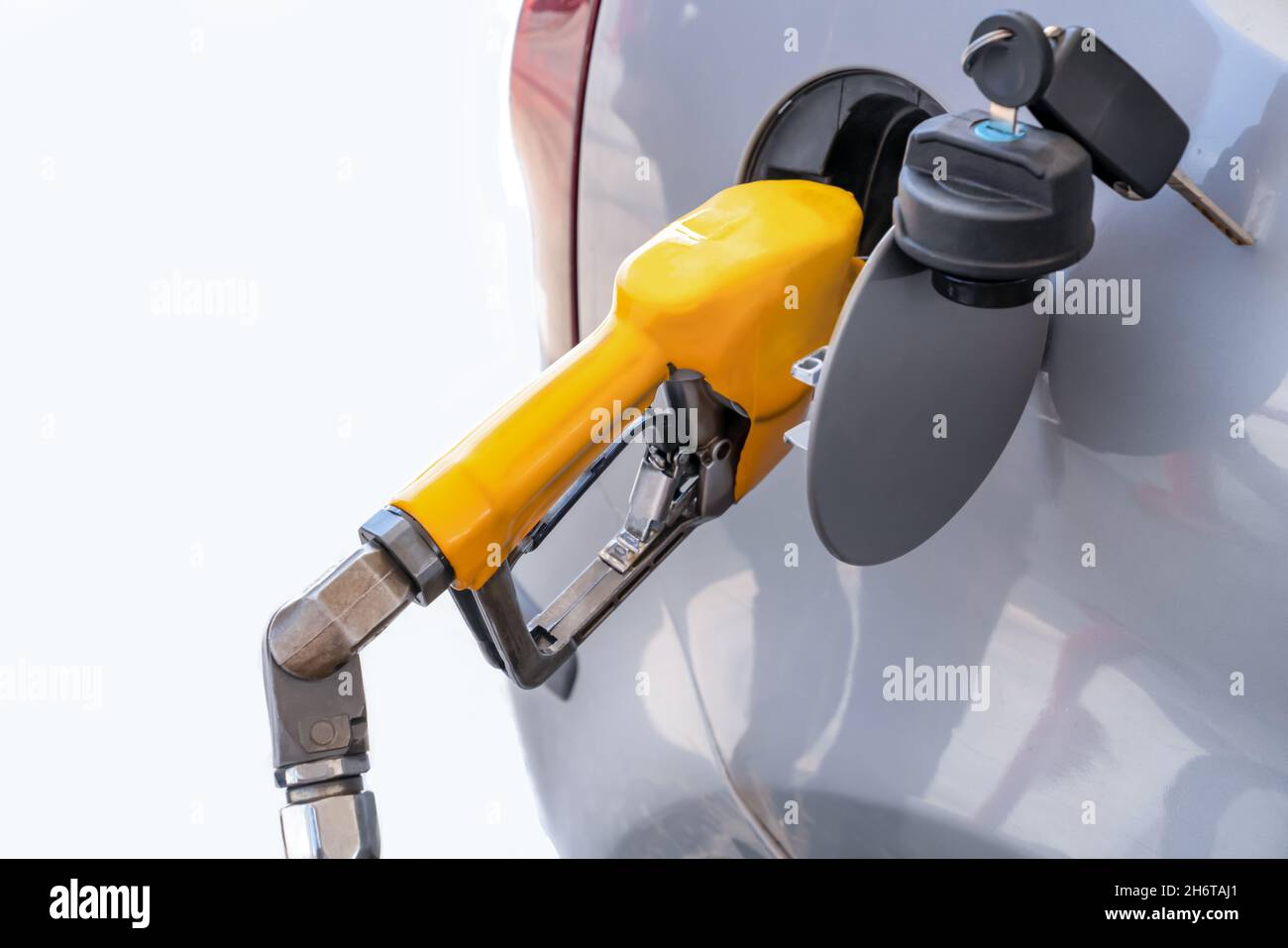Refueling gun in tank of gray car, while refueling car with gasoline ...