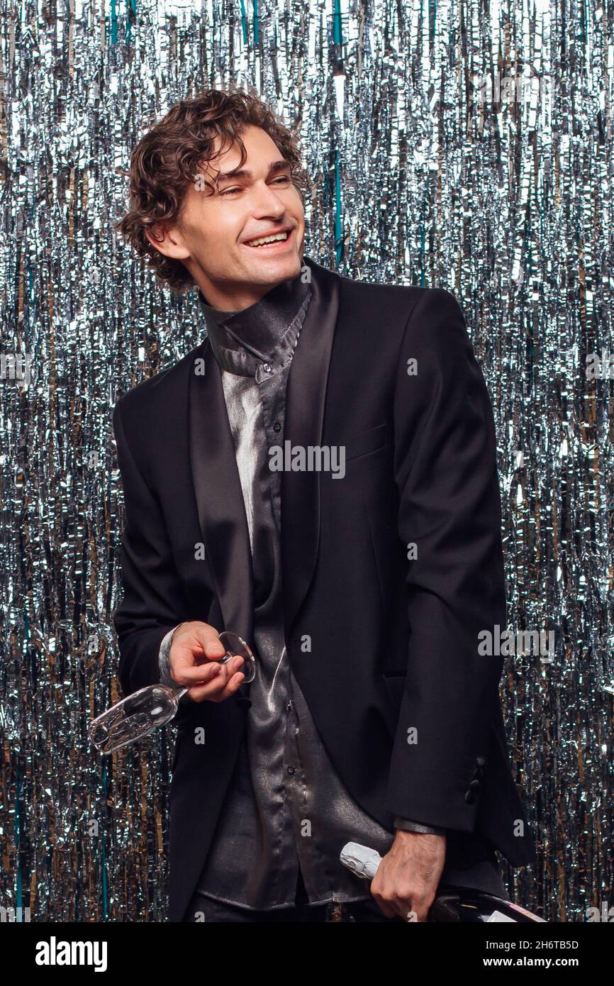 Happy tipsy man with bottle of champagne and wine glass at christmas or ...