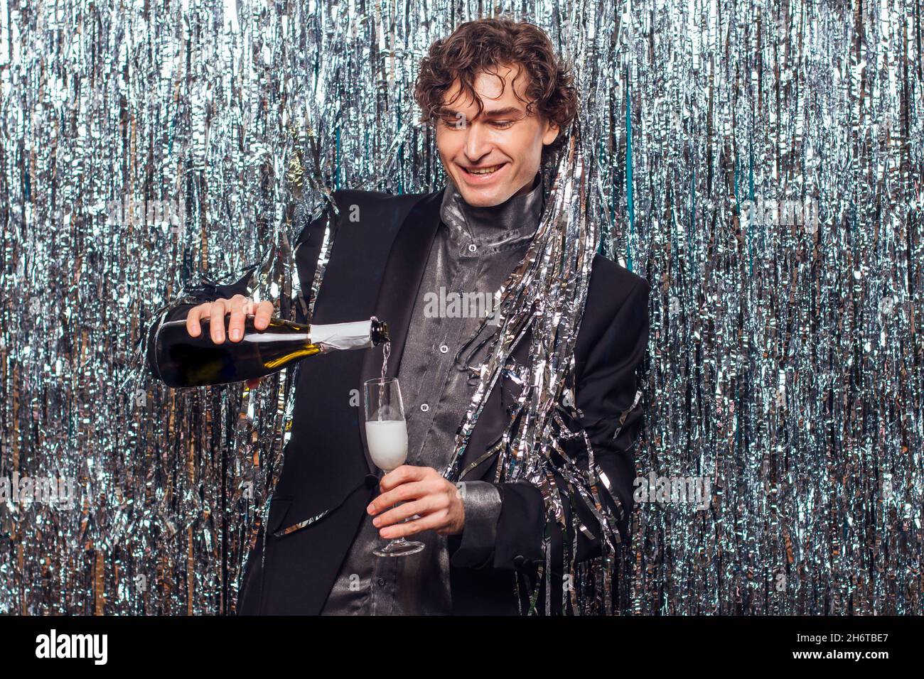 Happy tipsy man with bottle of champagne and wine glass at christmas or ...