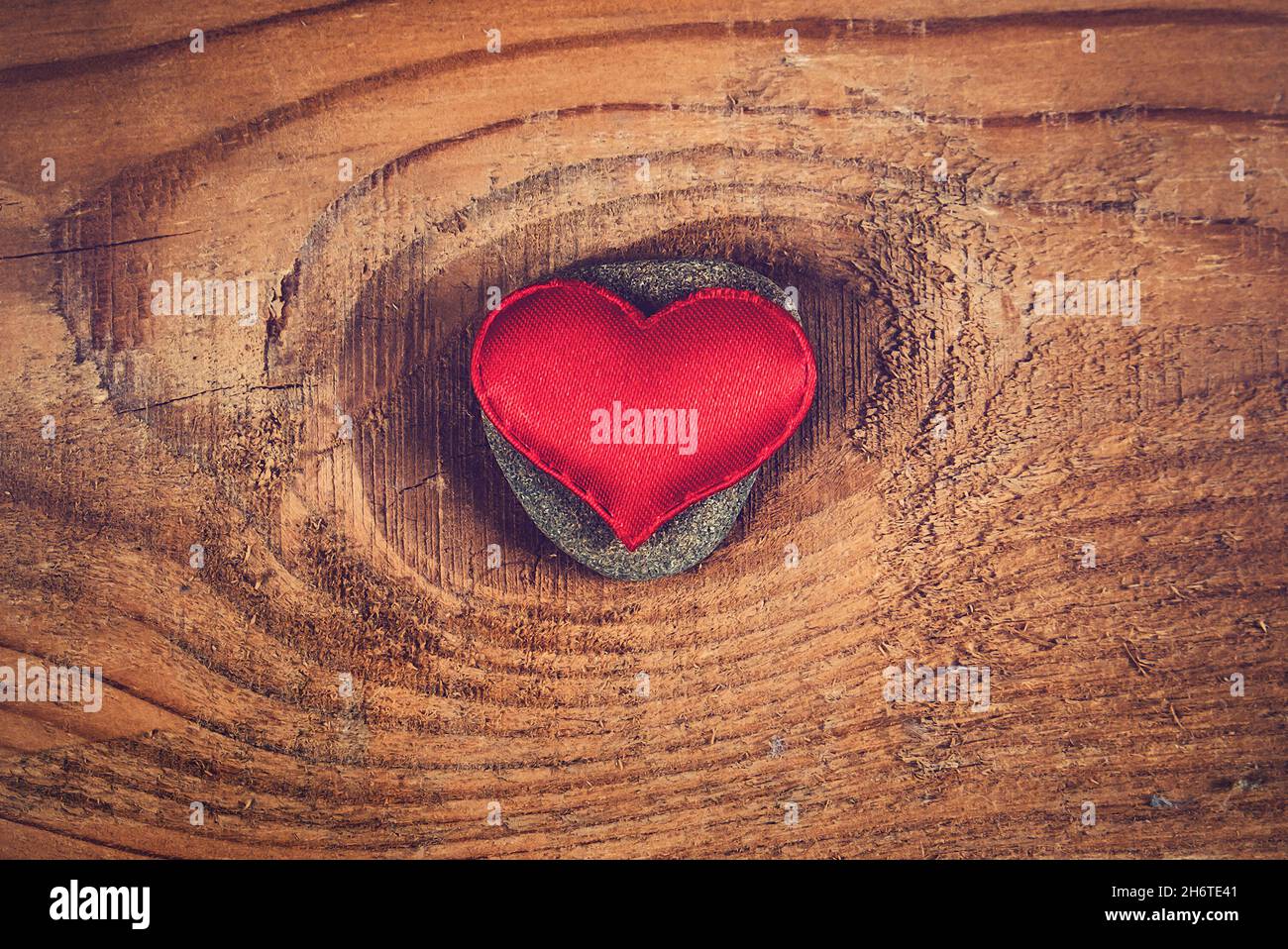 Red Heart Shape on a Pebble and Wooden Planks Background closeup Stock ...