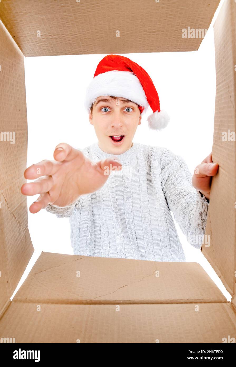Happy Young Man in Santa Hat looking inside a Box and reaching a Hand ...