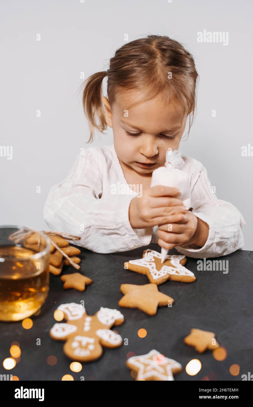 Child cooking and eating home made gingerbread cookies, stars, man ...