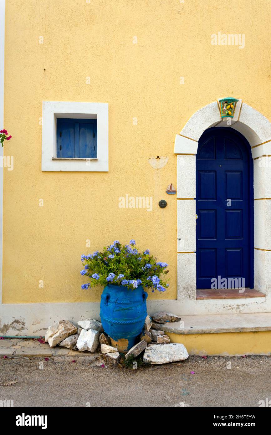 Yellow house with blue door and plant, Greece Stock Photo - Alamy