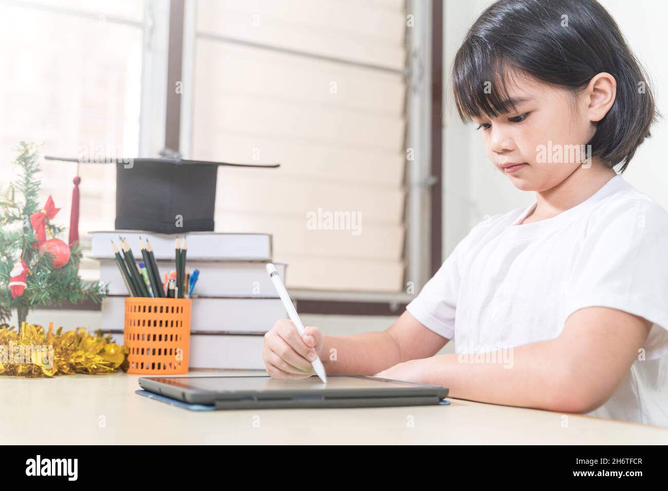 Asian female kid doing homework on a tablet -the concept of education ...