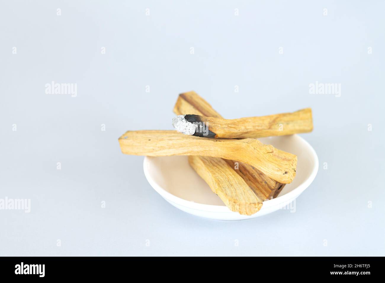 Palo santo holy wood on white ceramic plate. Meditation, healing ...