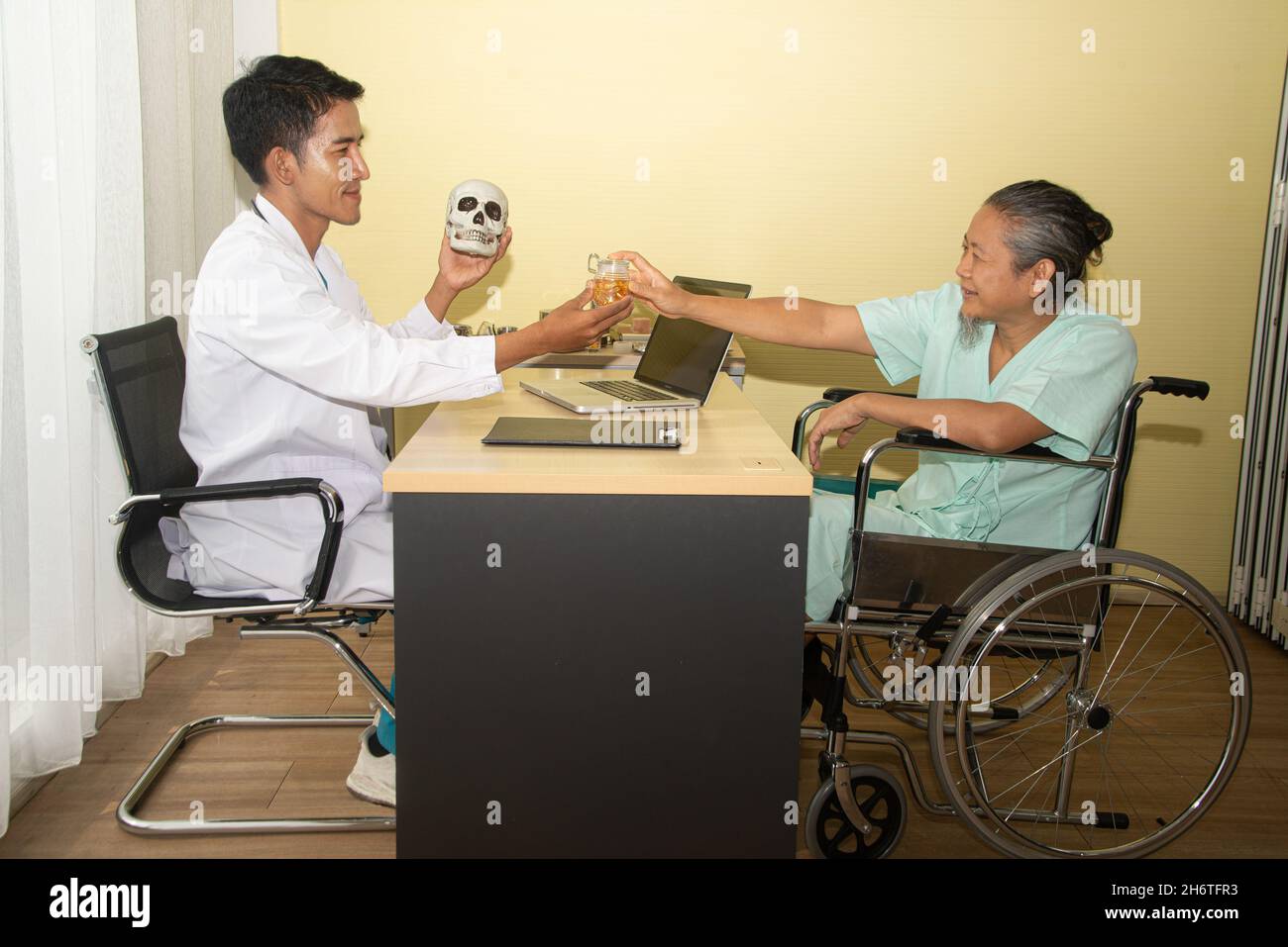 An Asian male doctor explains and diagnoses by displaying a skull model ...