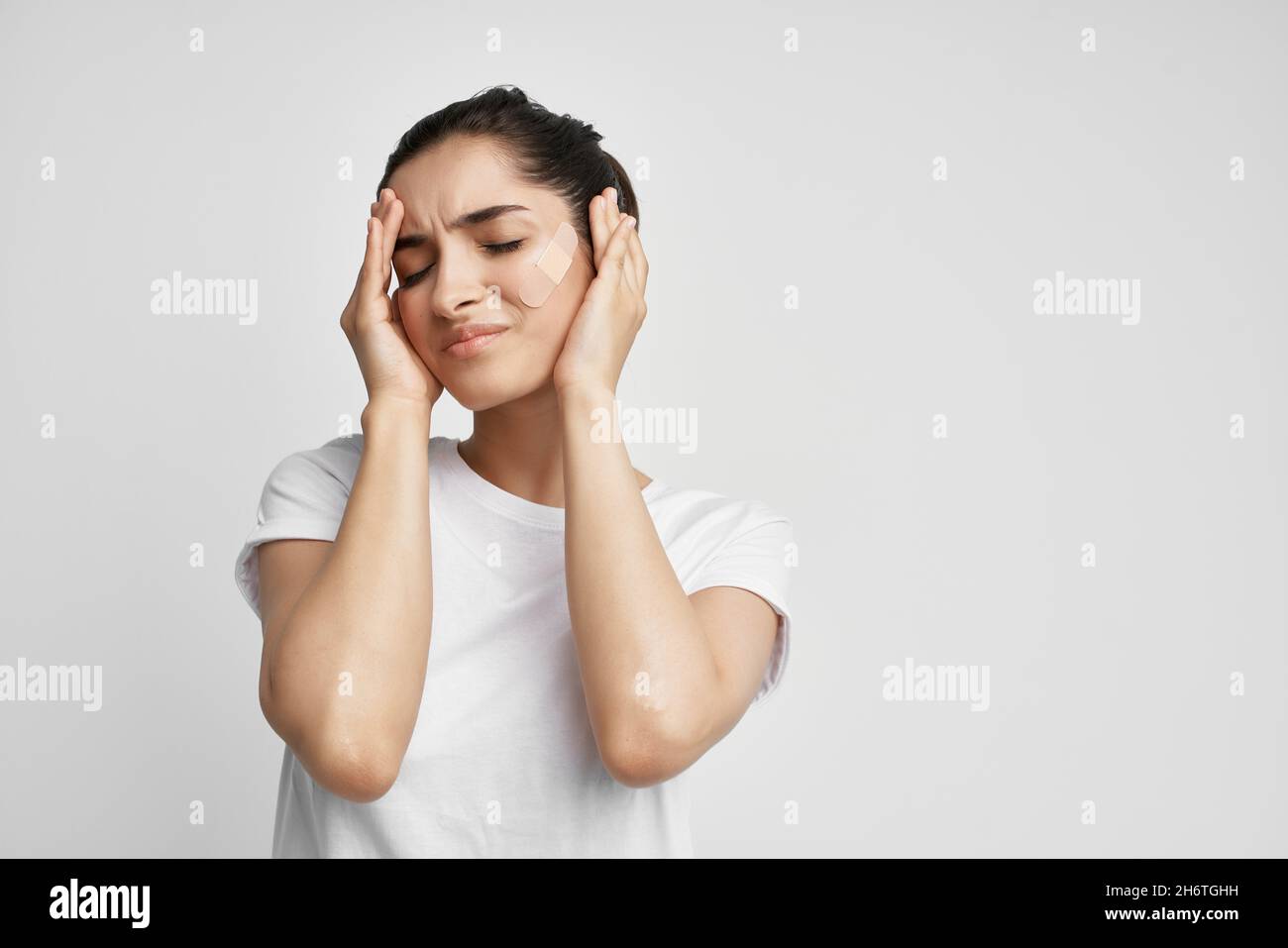 brunette holding his head trauma health problems isolated background ...