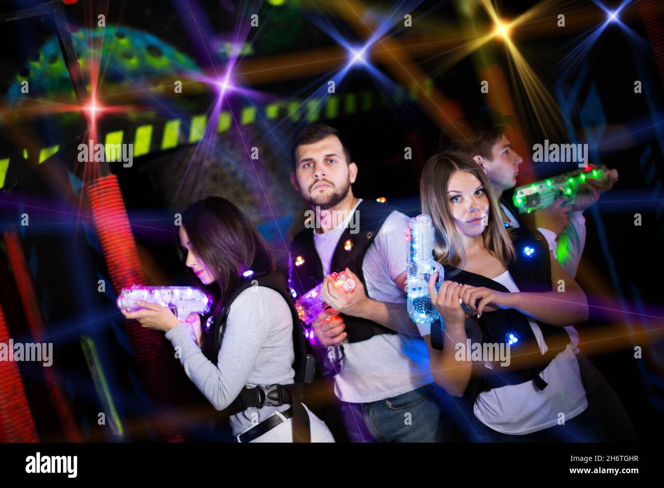 Young people playing laser tag in bright beams Stock Photo - Alamy