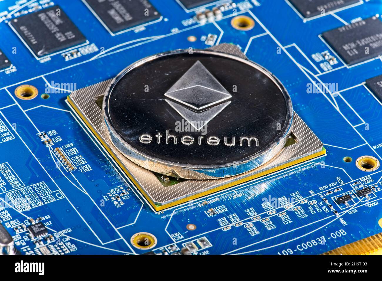 Shining silver metal ETH Ethereum coin on computer mother board Stock ...