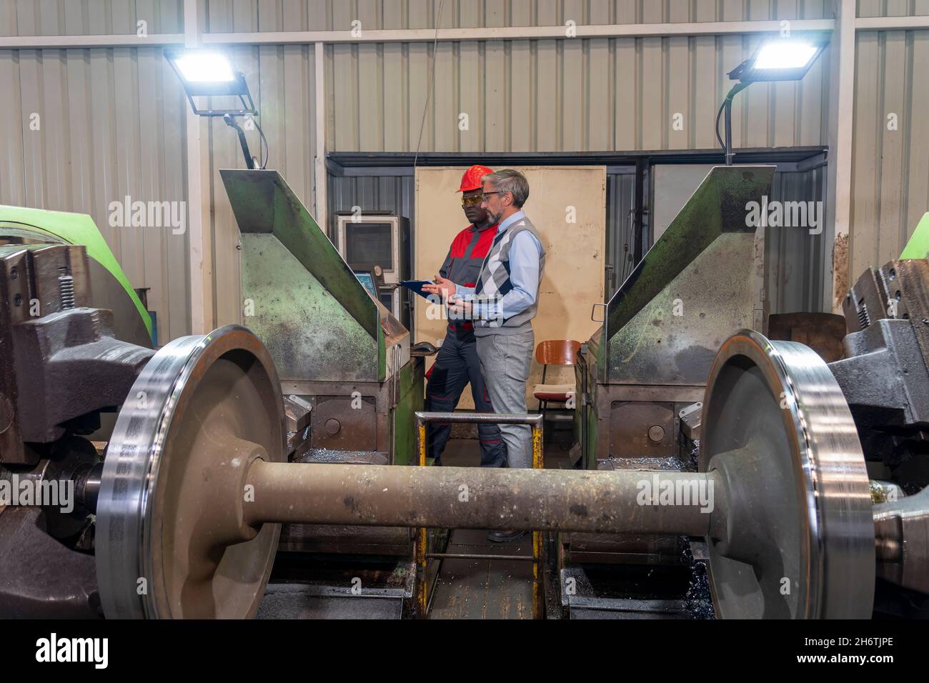 Multiracial Industrial Co-Workers Standing Next To CNC Controller And ...