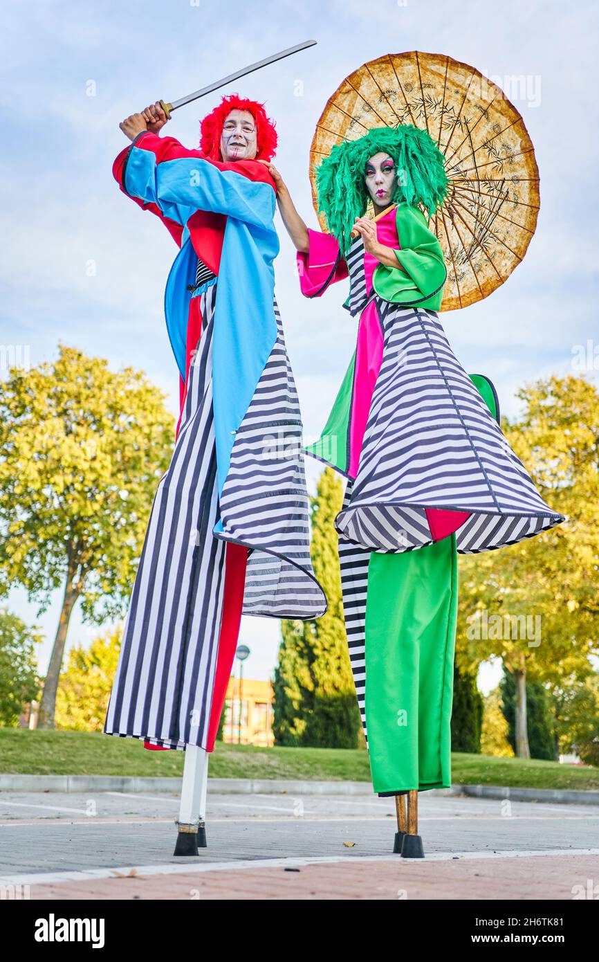 Full length of creative talented performers with face art in colorful ...