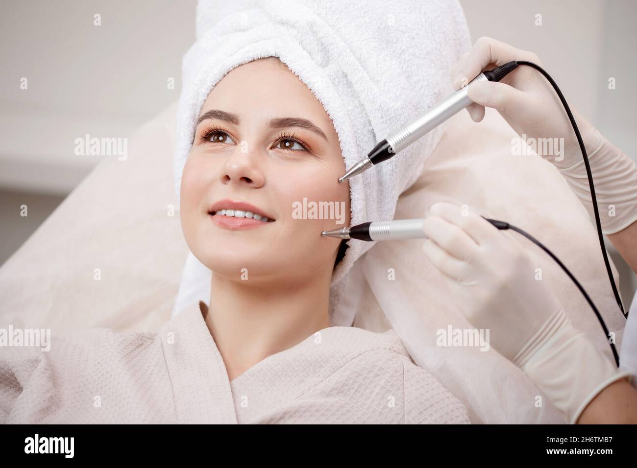 Young woman having stimulation microcurrent procedure for lifting skin ...