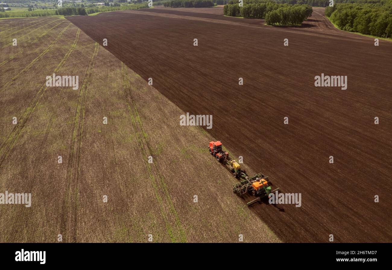 Farmer in tractor preparing land for sowing, cultivation and plows ...